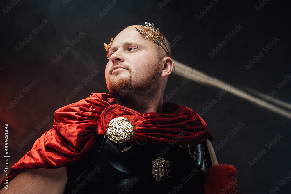 Roman imperial general poses looking away in black armour with red cape ...