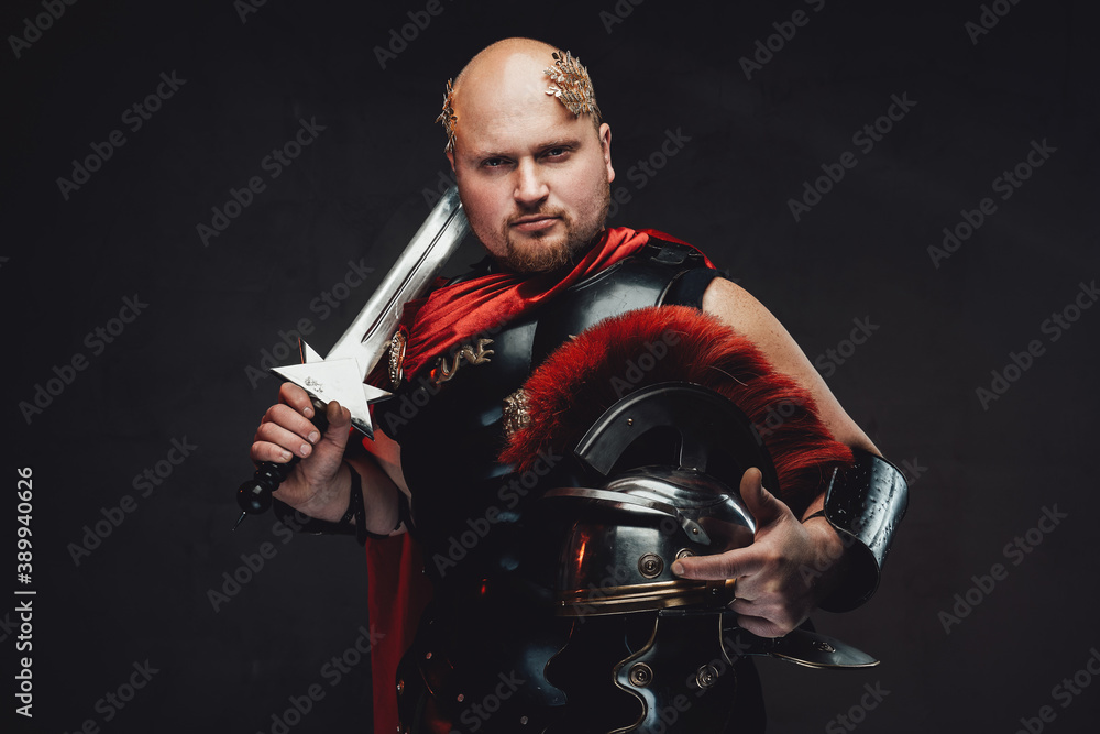 Warlike bald roman soldier in black armour and red cape with wreath on ...