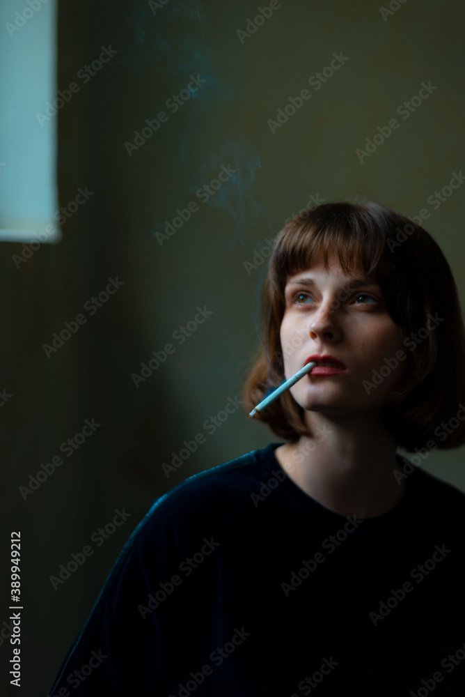 Portrait of a young beautiful girl of generation Z smoking a cigarette ...