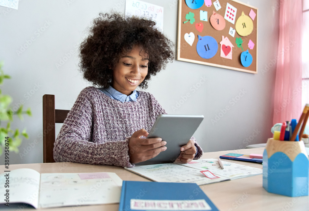 Smiling african kid girl holding digital tablet elearning. Happy mixed ...