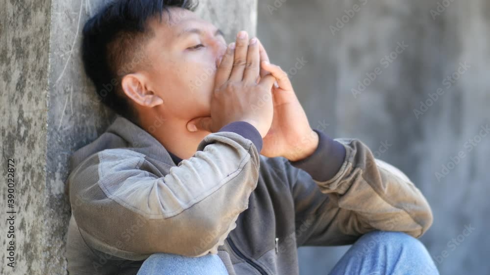Young handsome Indonesian desperate man, covering his face with his ...