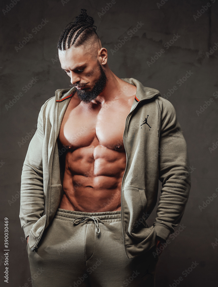 Powerful bodybuilder with dreadlocks and moustache in gray sportswear ...