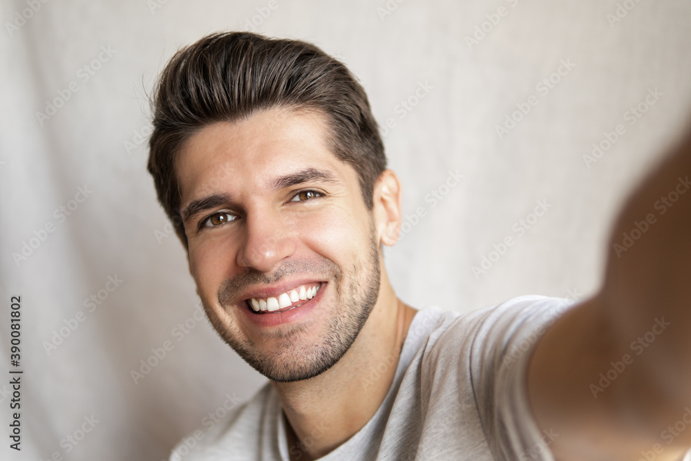 Portrait of a young attractive man doing a selfie with a gorgeous smile ...