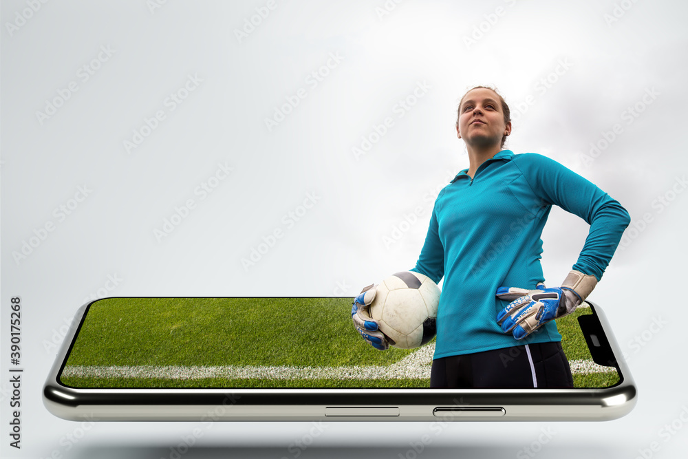 Young confident female goalkeeper holding the soccer ball in a soccer ...