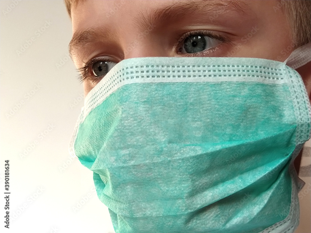 Masked child. The face of a 7-year-old boy in a protective surgical ...