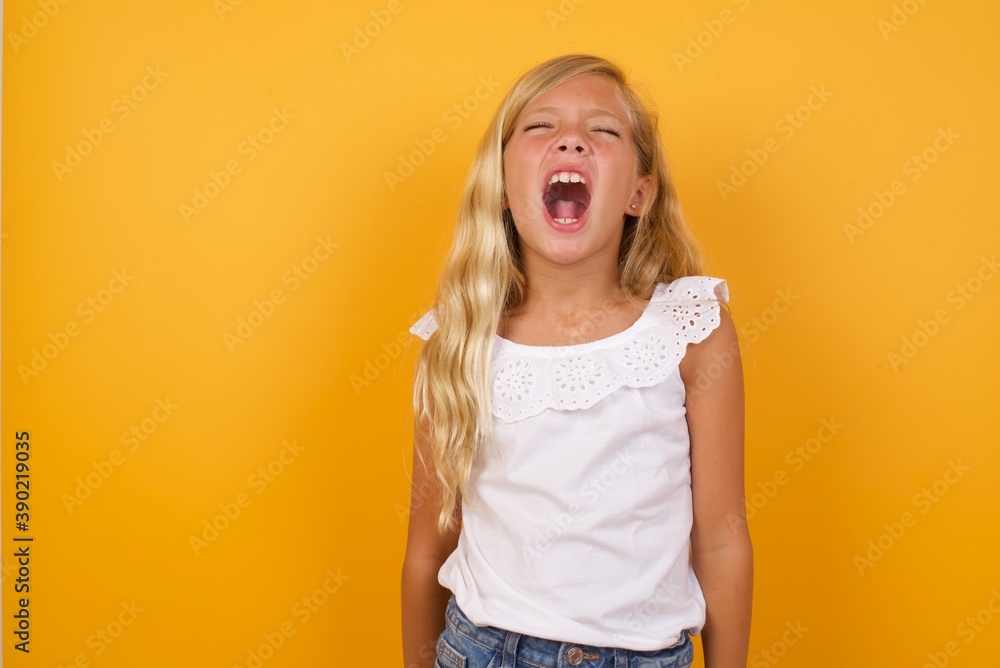 Stressful Beautiful Caucasian young girl standing against yellow ...