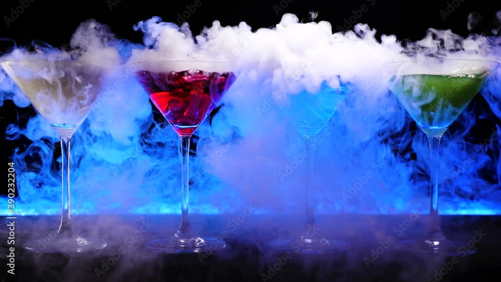 Various colorful cocktails with dry ice at bar counter close up ...