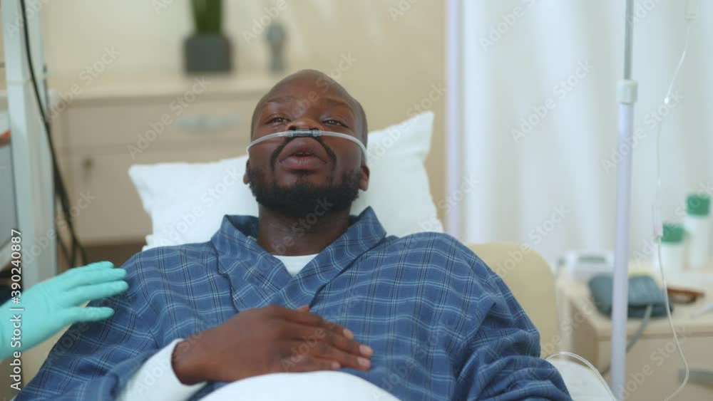 Poor sick african american young patient lying in bed hospital ...