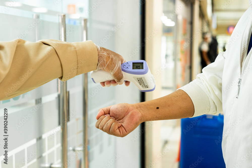 Doctor measuring patient's temperature with an infrared thermometer ...
