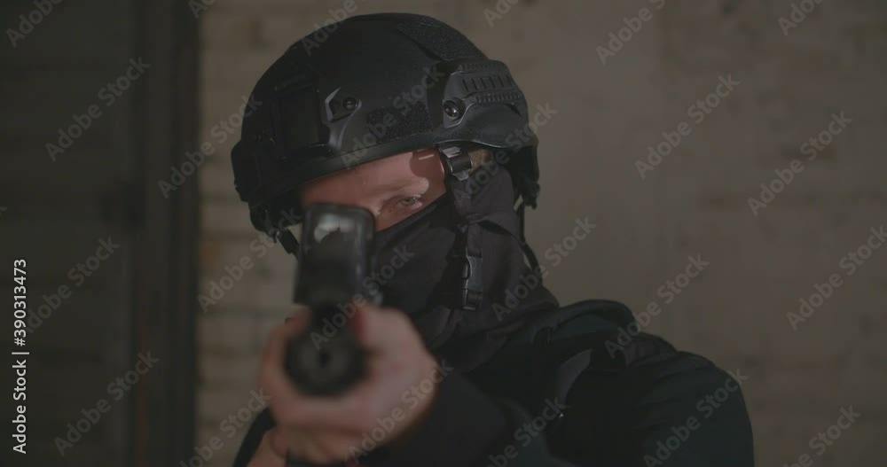 Swat police Officer pointing a gun at the camera with police lights ...