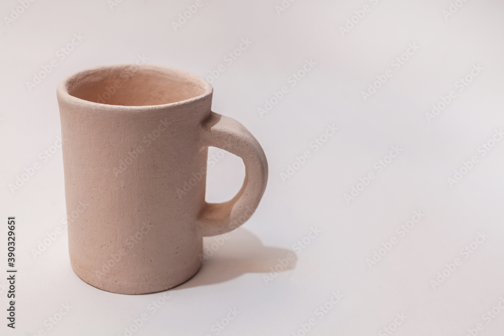Bisquit firing ceramics. Cup from fireclay on a white background ...