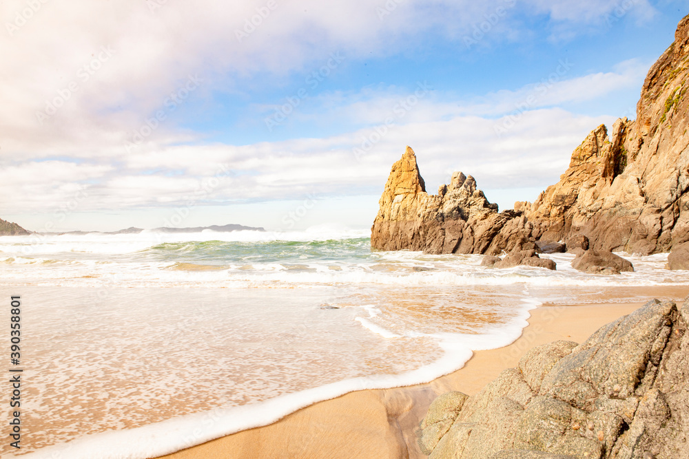 Playa rocosa en medio de un día soleado y lleno de olas Stock Photo ...