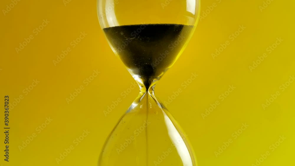 Shot of a sand clock measuring time while the sand is falling down ...