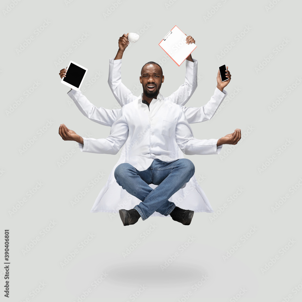 Handsome african doctor, multi-armed man levitating isolated on grey ...