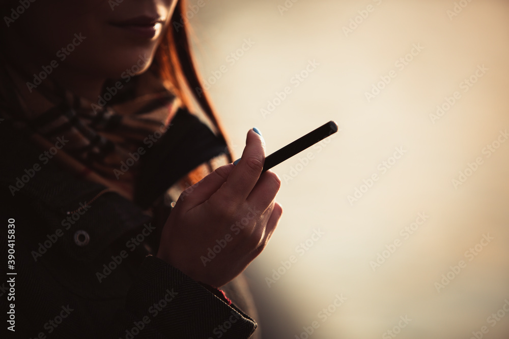 Young girl smoking vape pen outdoor.Brunette female models vaping ...