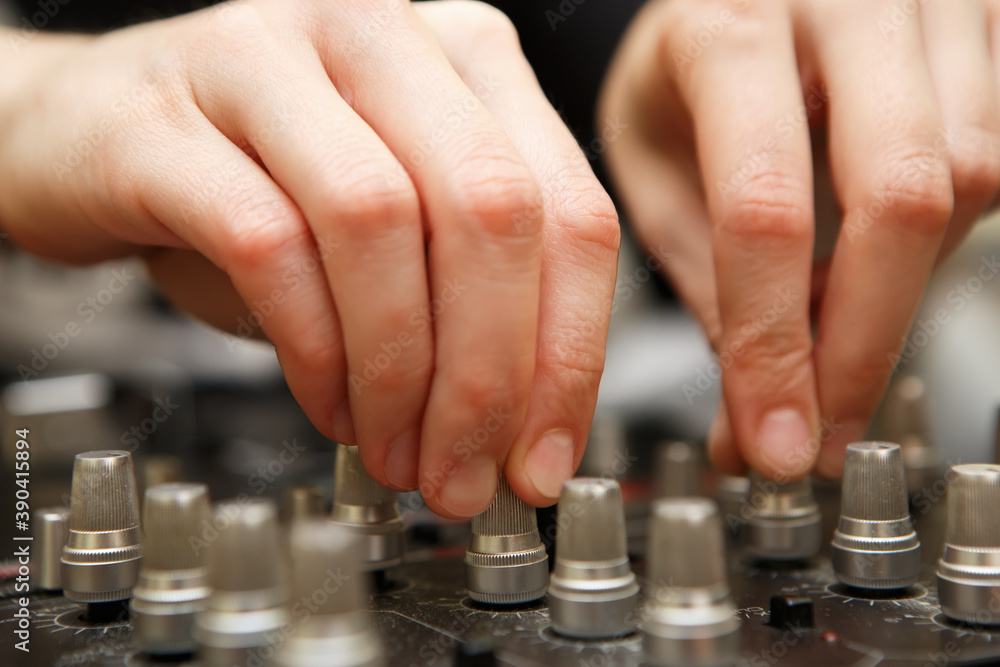 Hands of female hip hop dj mixes musical tracks with sound mixer ...