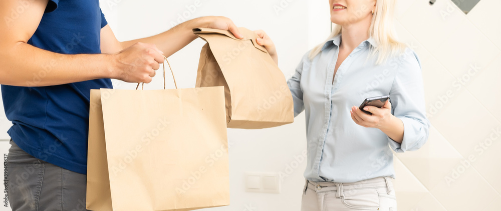 woman receiving boxes from postman at the door in home delivery concept ...