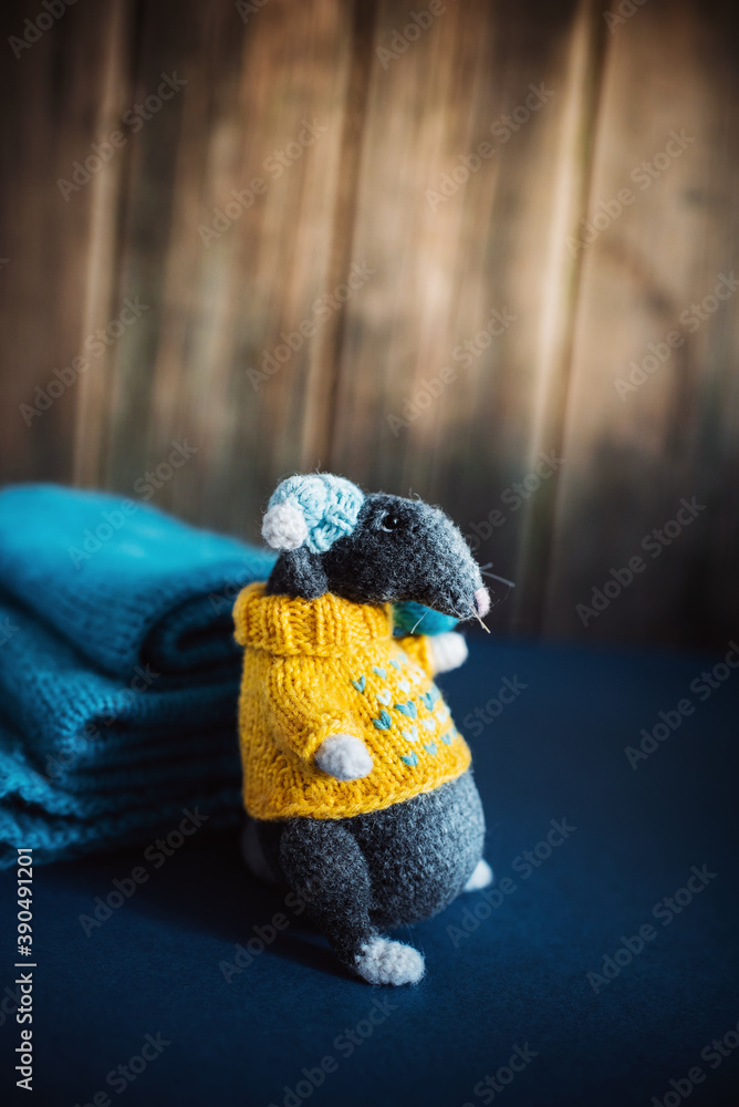 Handmade knitted toy. Amigurumi black rat toy in blue hat and yellow ...