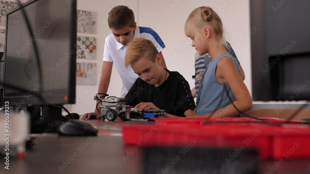 Group of kids building robot constructor from the plastics details ...