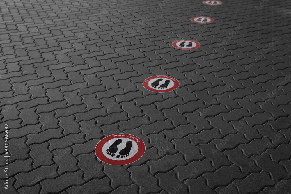 Stand here foot sign or symbol on the floor, keep distance please after ...