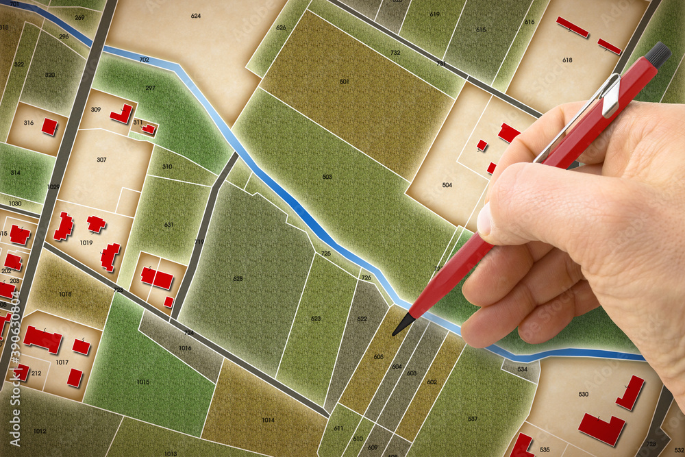 Engineer drawing an imaginary cadastral map of territory of a rural ...