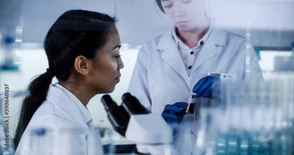 Female doctors testing samples in futuristic laboratory. Using ...
