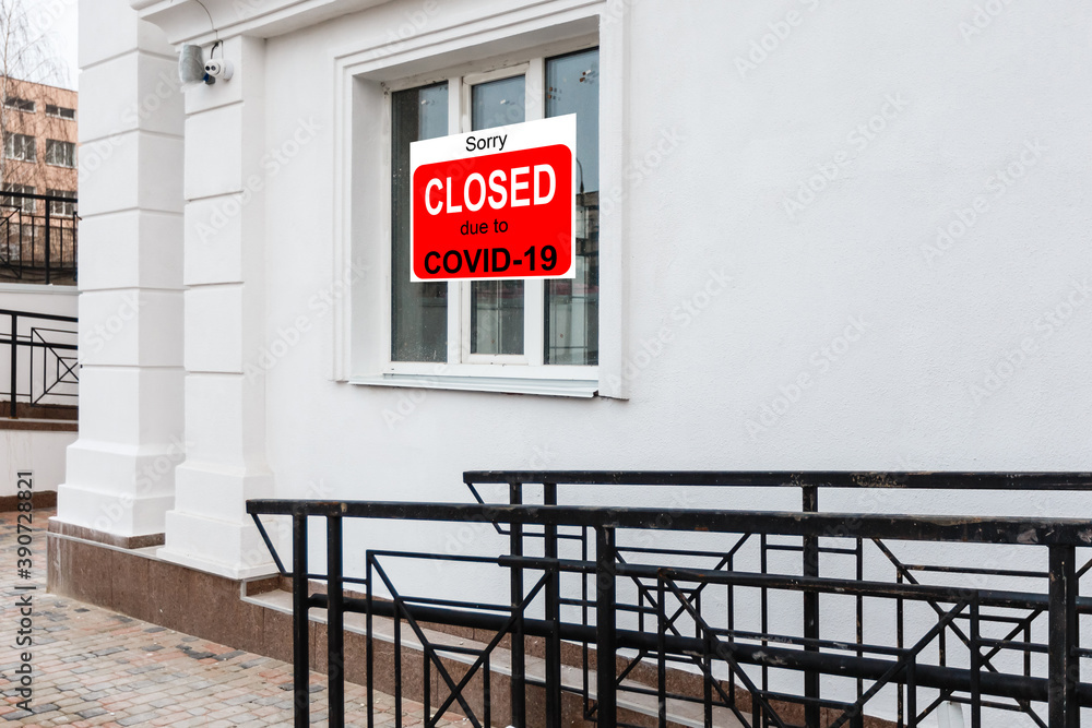 Business center closed due to COVID-19, sign with sorry in door window ...