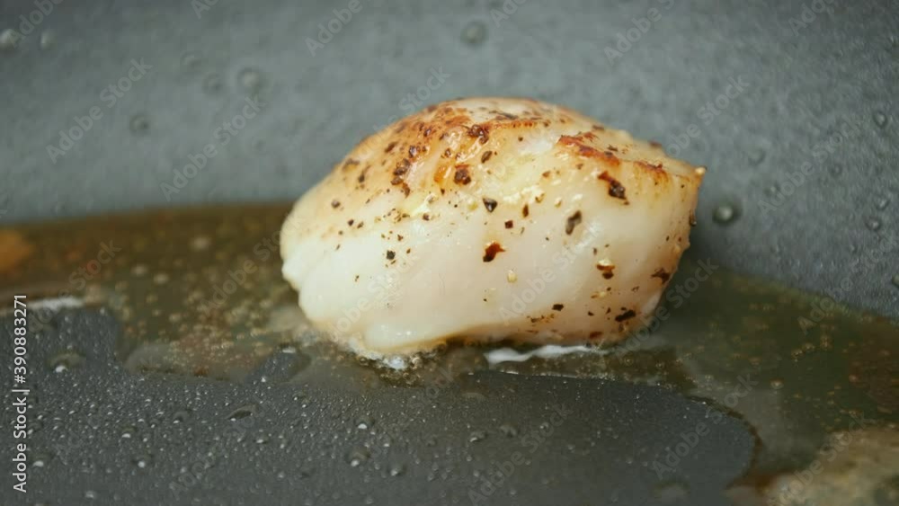 Close-up frying Raw Sea Scallops into a pan with oil on a gas stove in ...