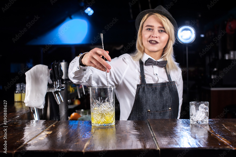Professional woman mixologist creates a cocktail while standing near ...