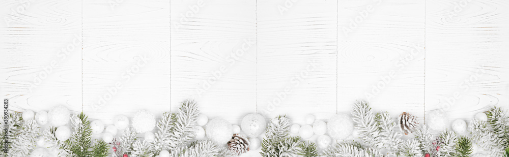 Winter bottom border with snowy branches and white Christmas baubles ...