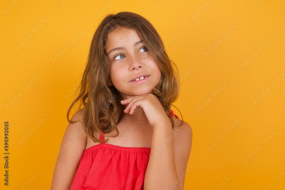 Dreamy Caucasian young girl standing against yellow background with ...