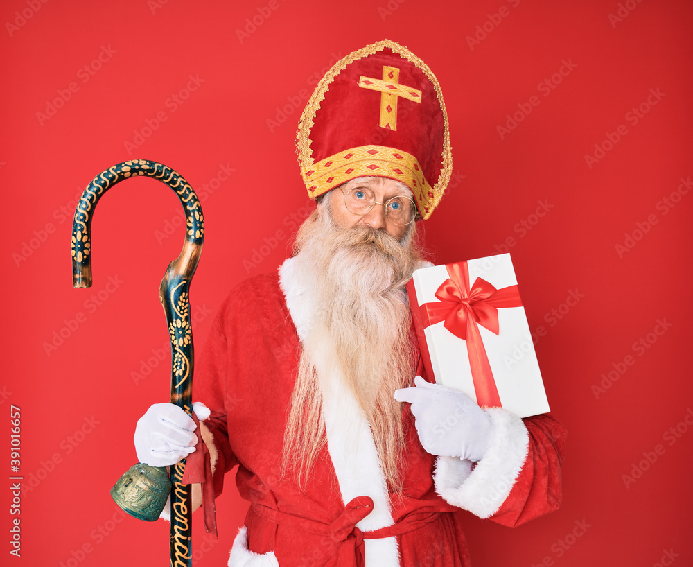 Old senior man with grey hair and long beard wearing saint nicholas ...