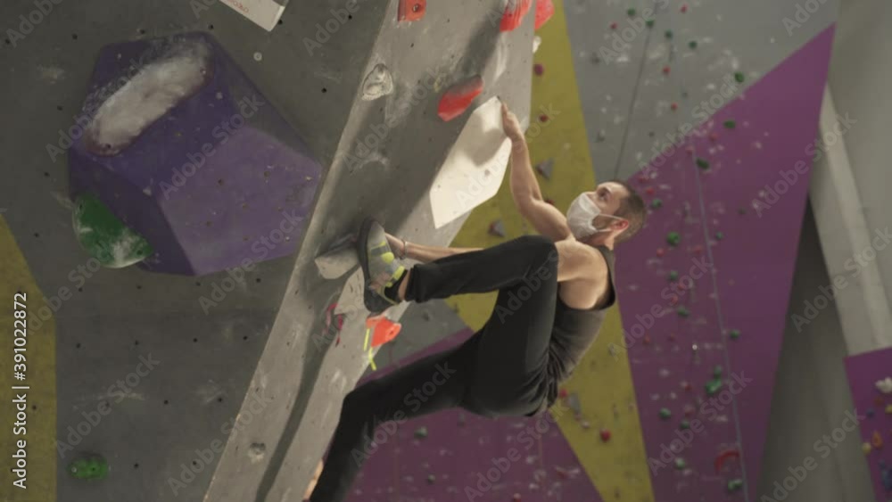 man climbing on a 45 degree incline climb, person practicing in a ...