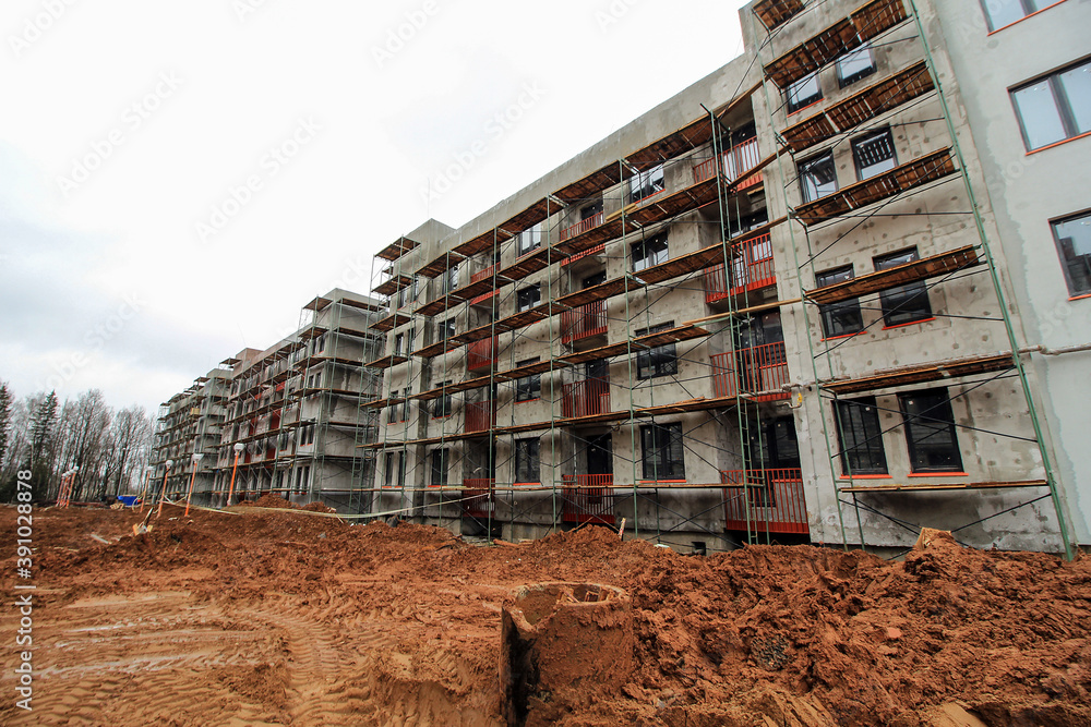 Tall building under construction with scaffolds. Construction site ...