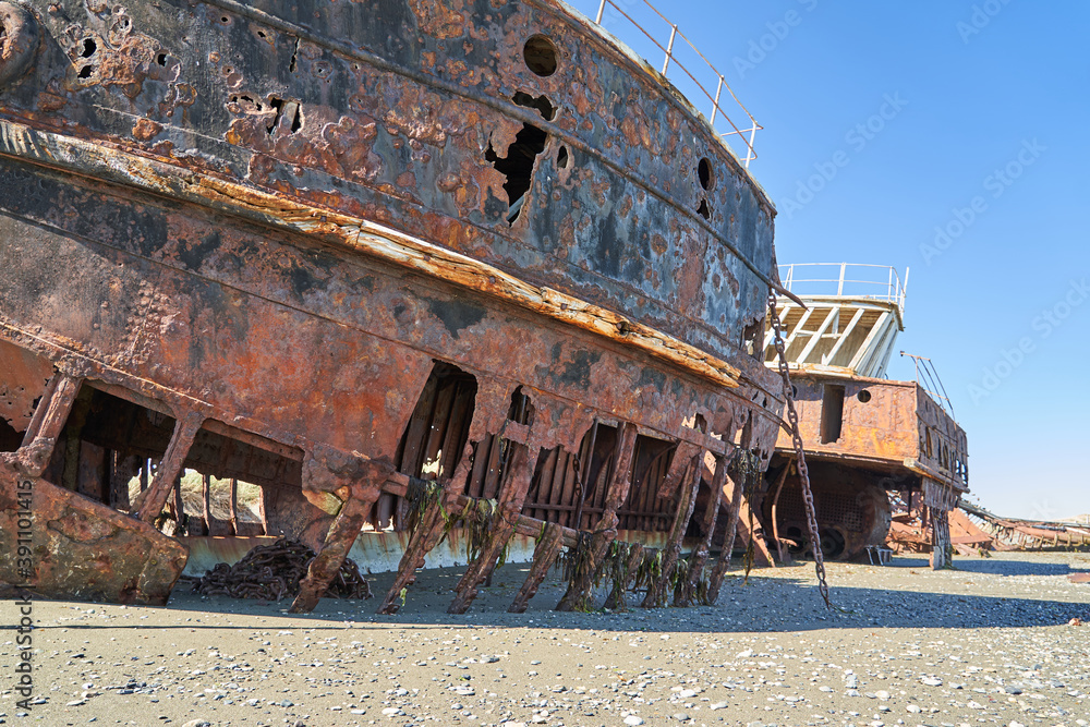 old rusty and rotten ship wreck with holes in its carcass, lying on the ...