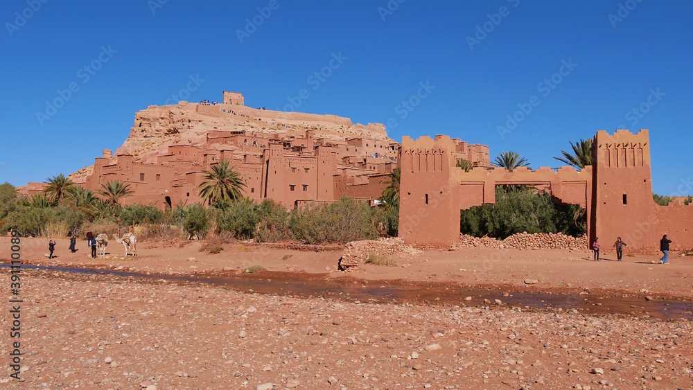 Tourists shooting pictures with a camel below historic Moorish ksar Ait ...