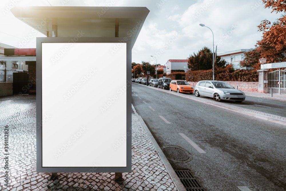 A bus stop near the road with a mockup of a blank advert poster on it ...