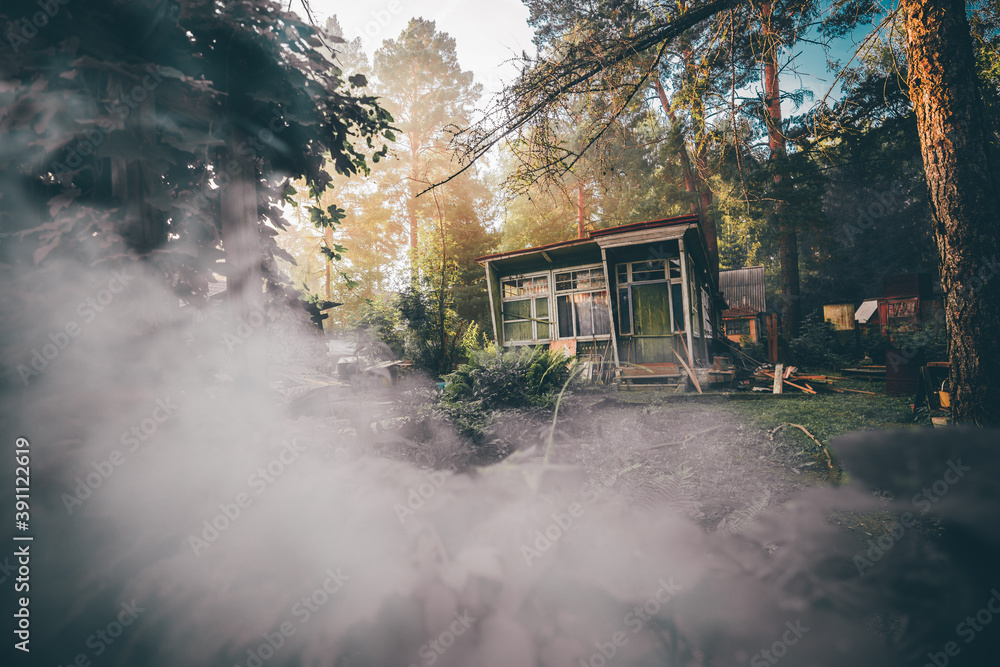 A wide-angle view of an old desolate one-story summer shack with glass ...