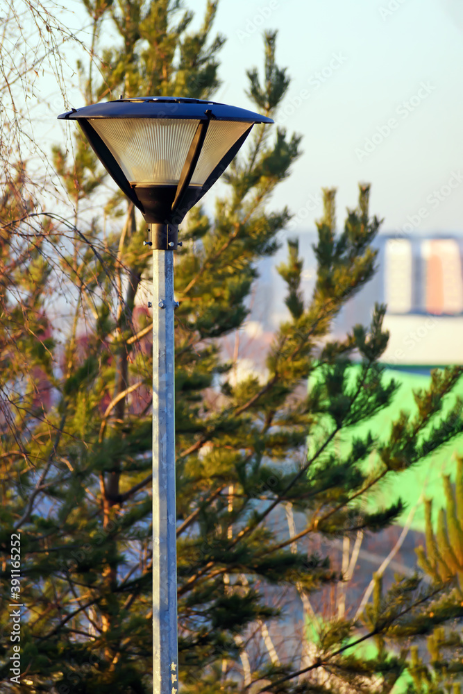 The upper part of a street lighting fixture installed in a Park alley ...