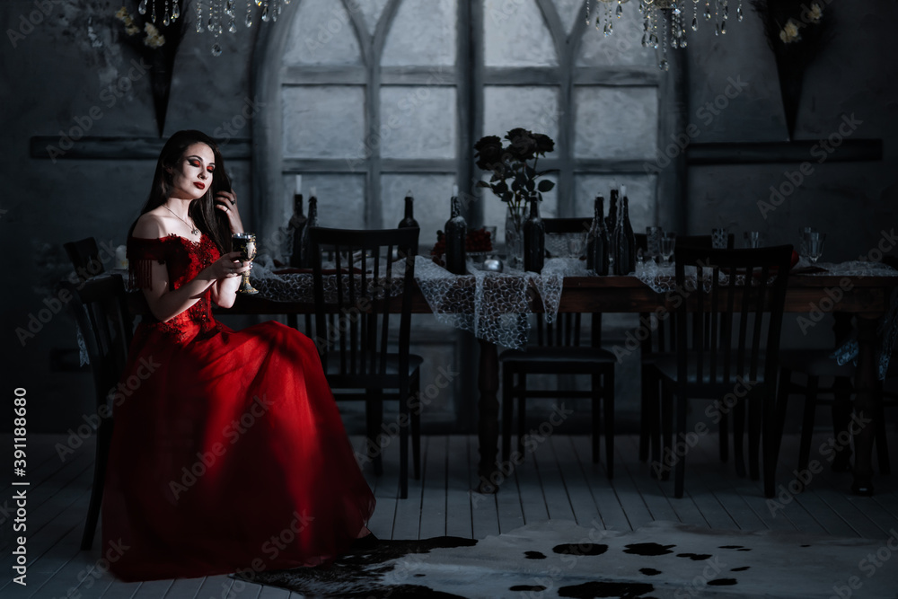 Bloodthirsty female vampire in red dress. Medieval interior Stock Photo ...