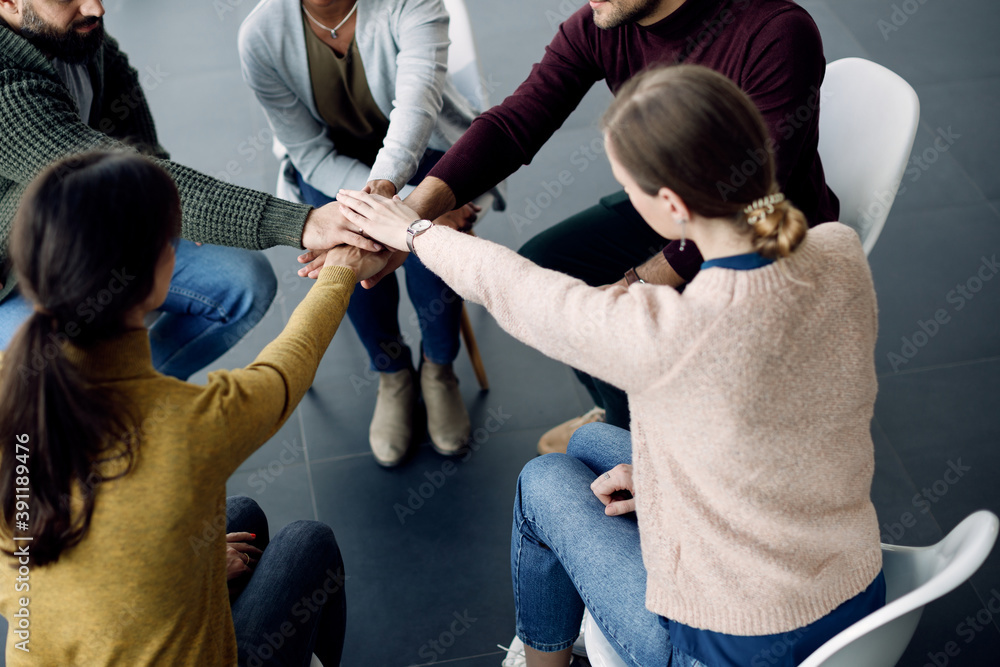 Participants of group therapy gathering hands in unity during a session ...