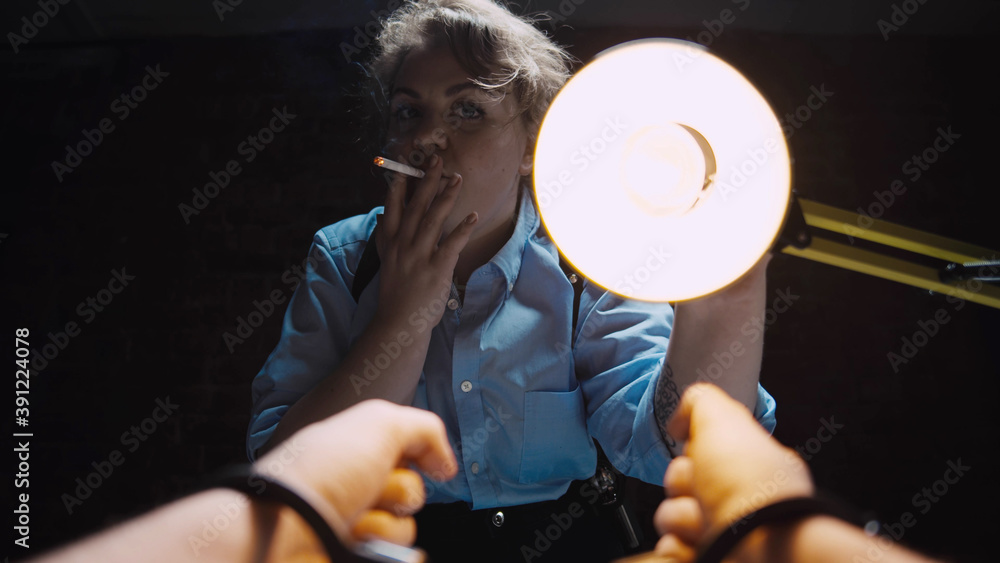 Female police officer interrogating criminal and smoking cigarette ...