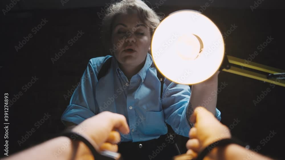 Female police officer with badge interrogating criminal and smoking ...
