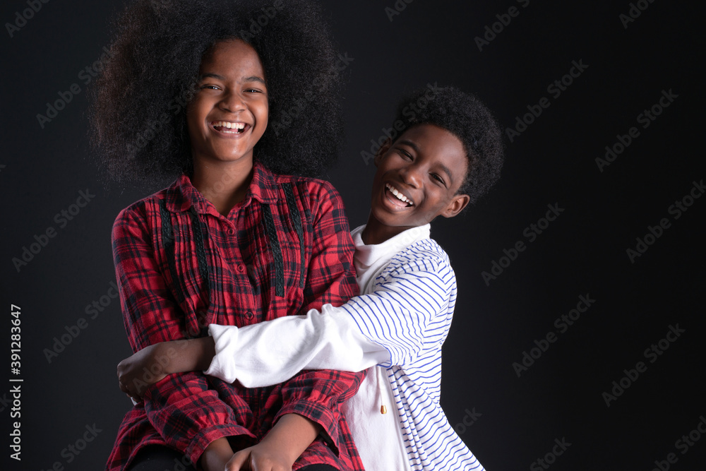 Dark skinned younger brother hugging with smiley face beside of his ...