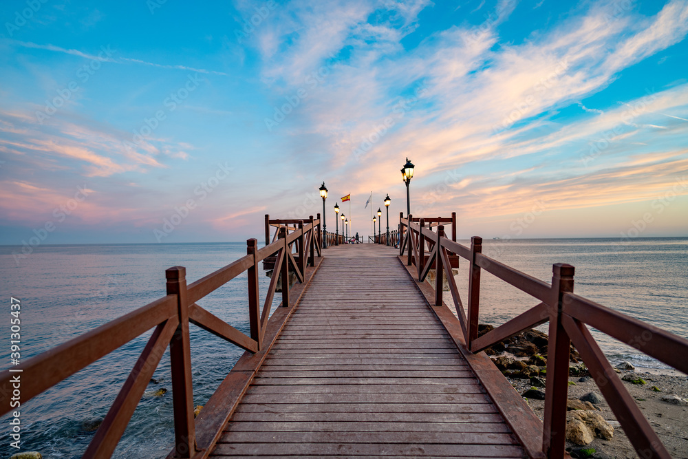 Vista de un muelle en una playa de Marbella al atardecer. Concepto de ...