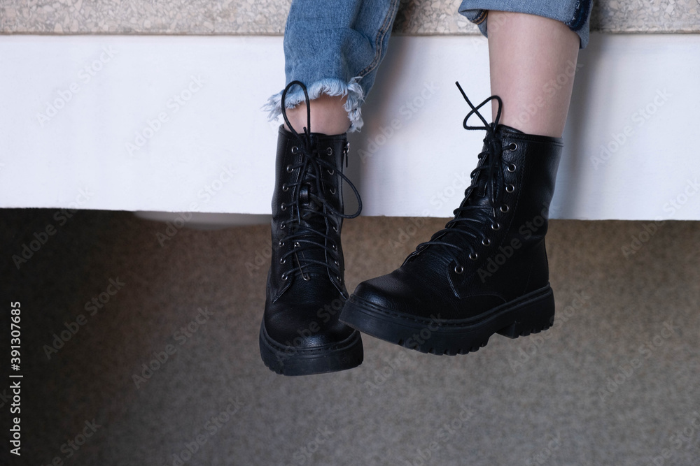 legs, clad in black boots, pushed over the railing, dangling Stock ...