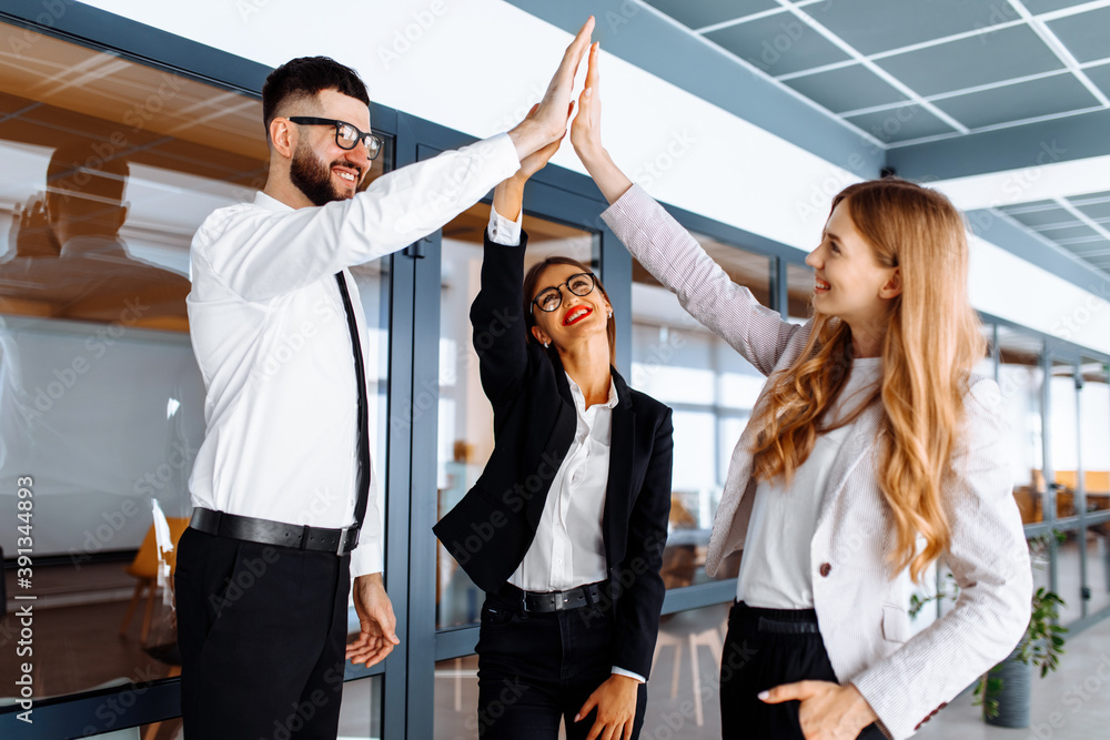 Happy successful business team celebrating a victory by folding their ...