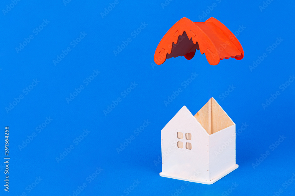 Wooden model of a house without a roof on a blue background. The red ...