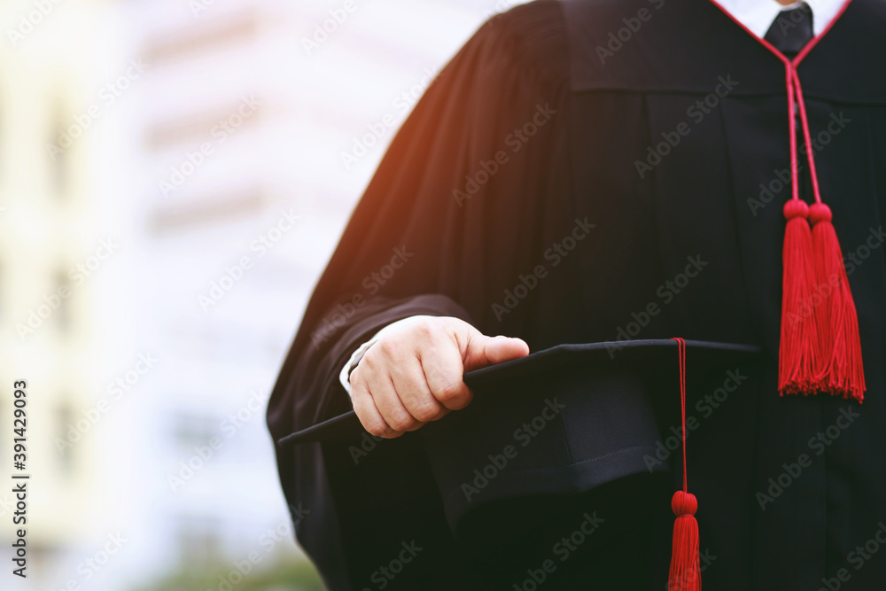 graduates ,close up student holding hats and tassel red in hand during ...