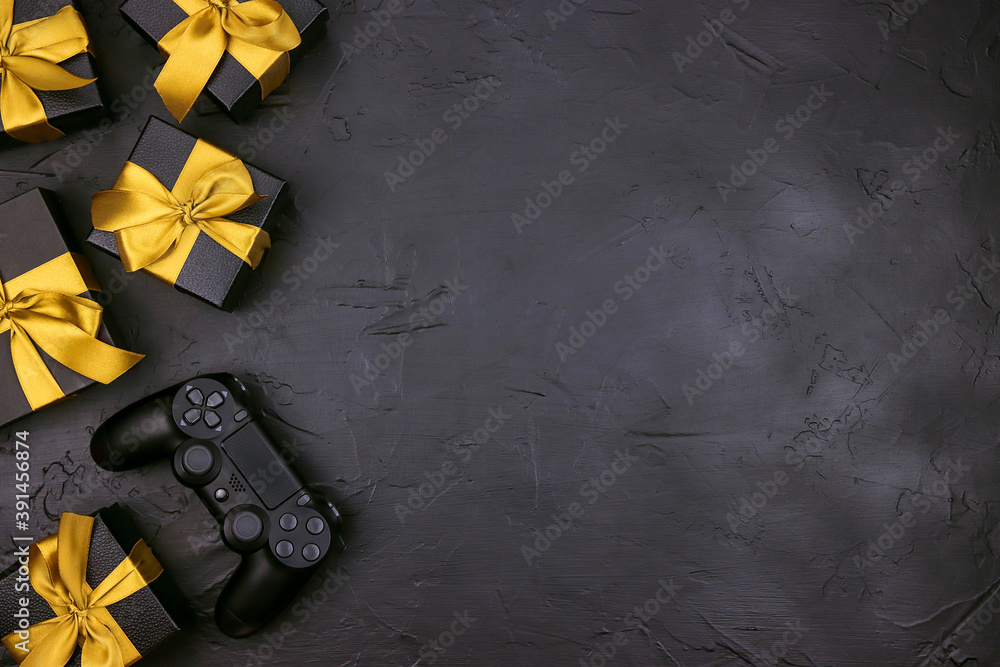 Black background with joystick gaming controller and gift boxes with ...